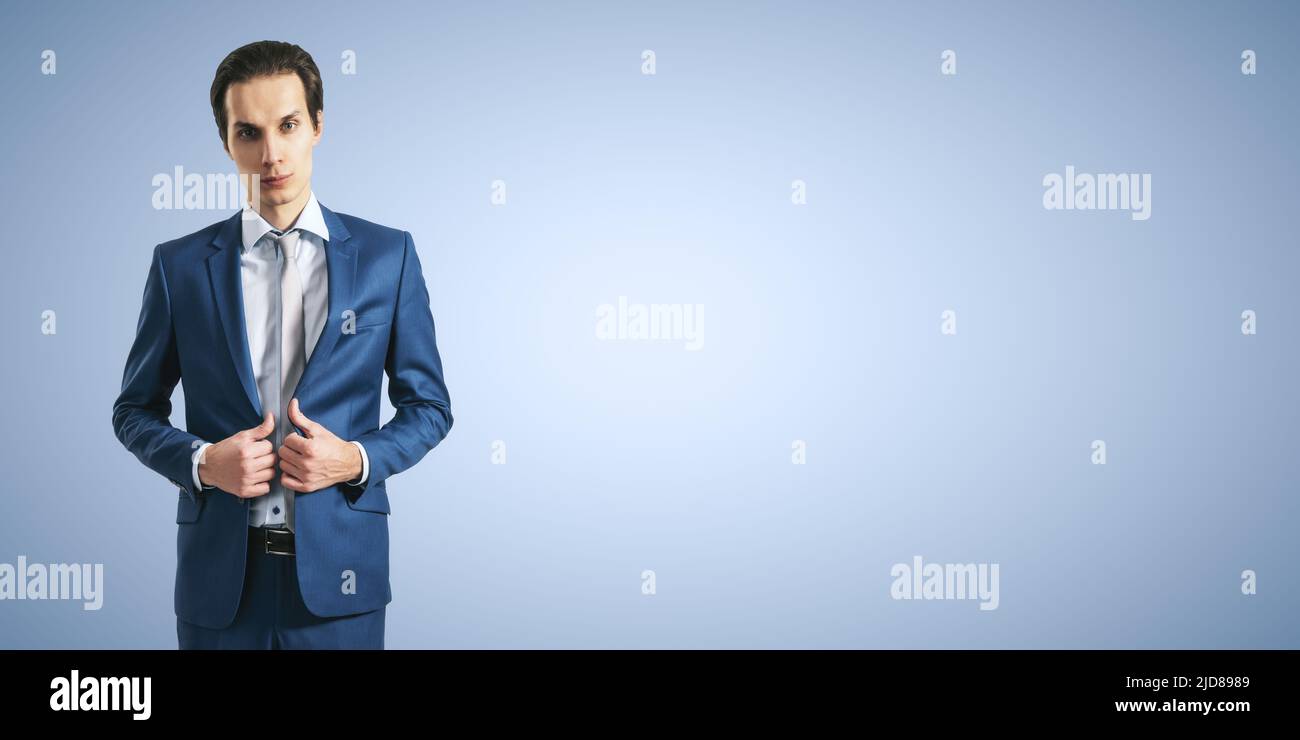 Young self-made businessman in blue suit isolated on light blue wall ... Young self-made businessman in blue suit isolated on light blue wall ...