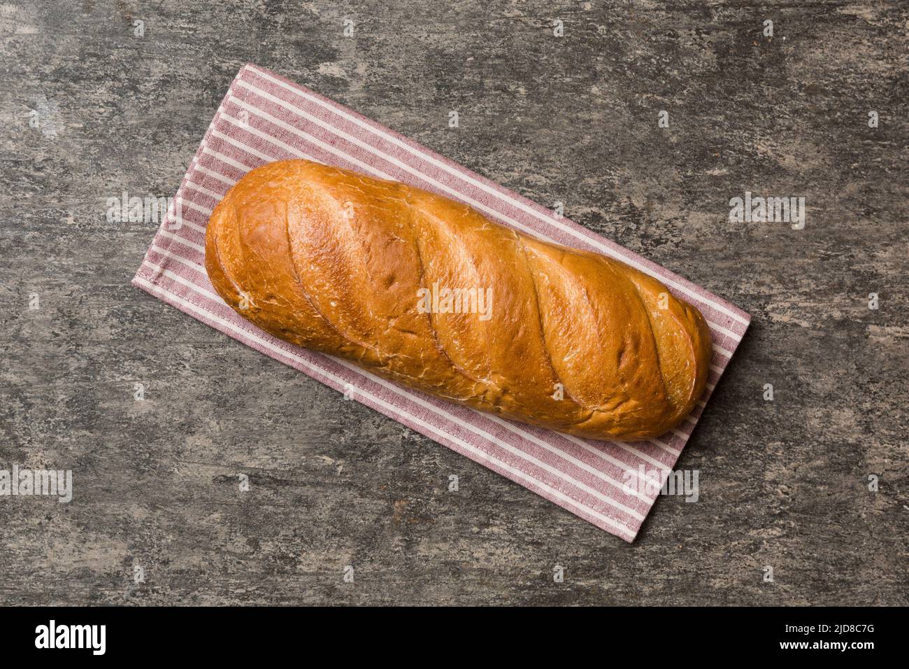 freshly baked bread with napkin on rustic table top view. Healthy white ...