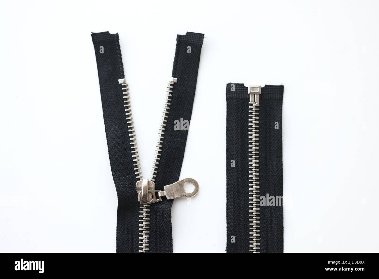 Open metal zippers for clothing on white background Stock Photo - Alamy
