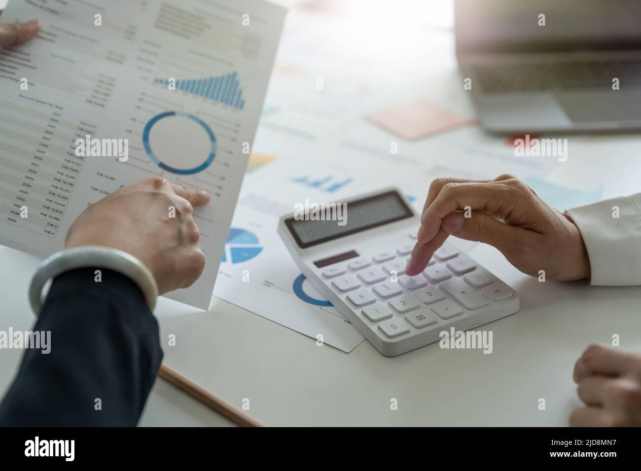 Business accounting team using a calculator and laptop computer to ...