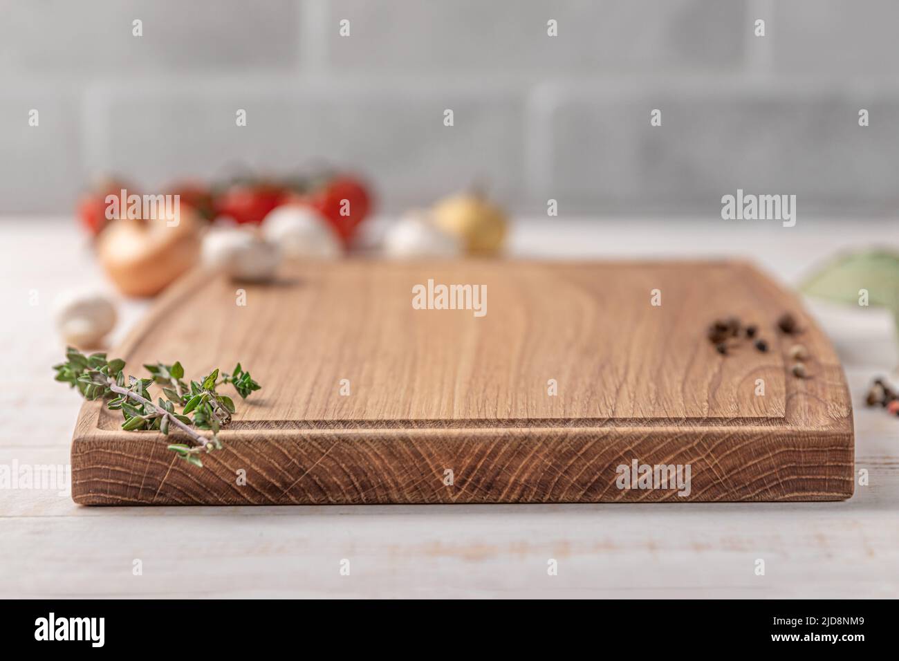square wooden cutting board with edging. cherry tomatoes and spices on ...