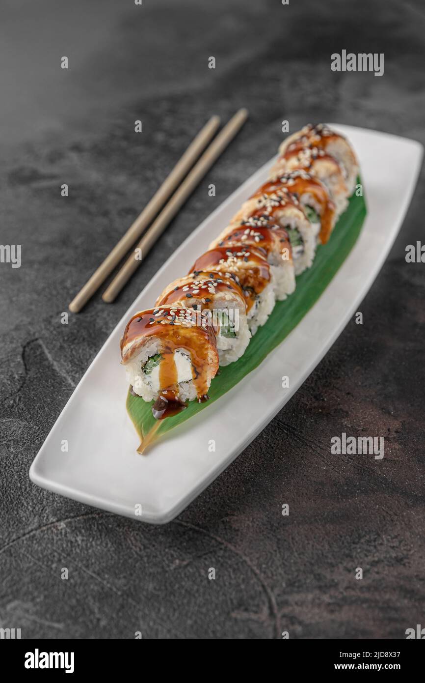 set of philadelphia roll with eel and green bamboo leaf in a white ...