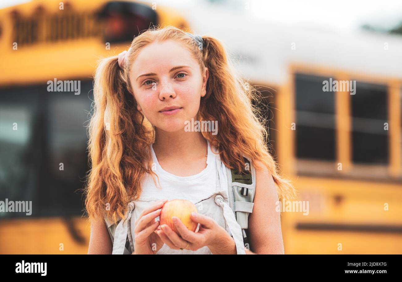 School girl at the front of the school bus with apple Stock Photo - Alamy