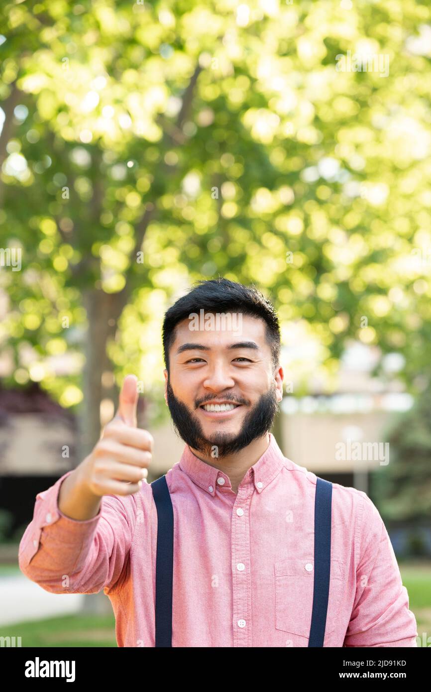 Vertical portrait of an asian man gesturing being well Stock Photo - Alamy