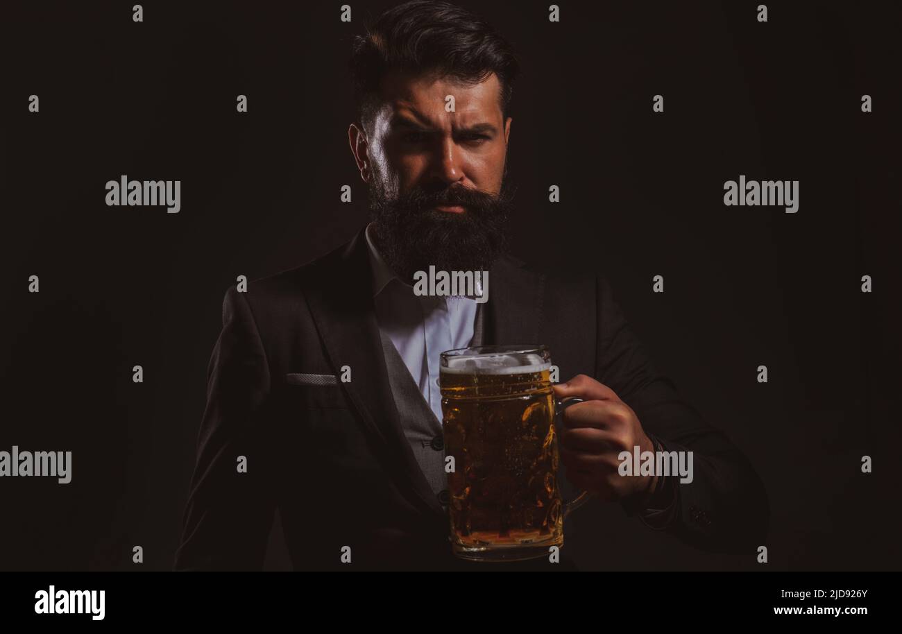 Portrait of serious bearded man drinking beer. Happy brewer holding ...
