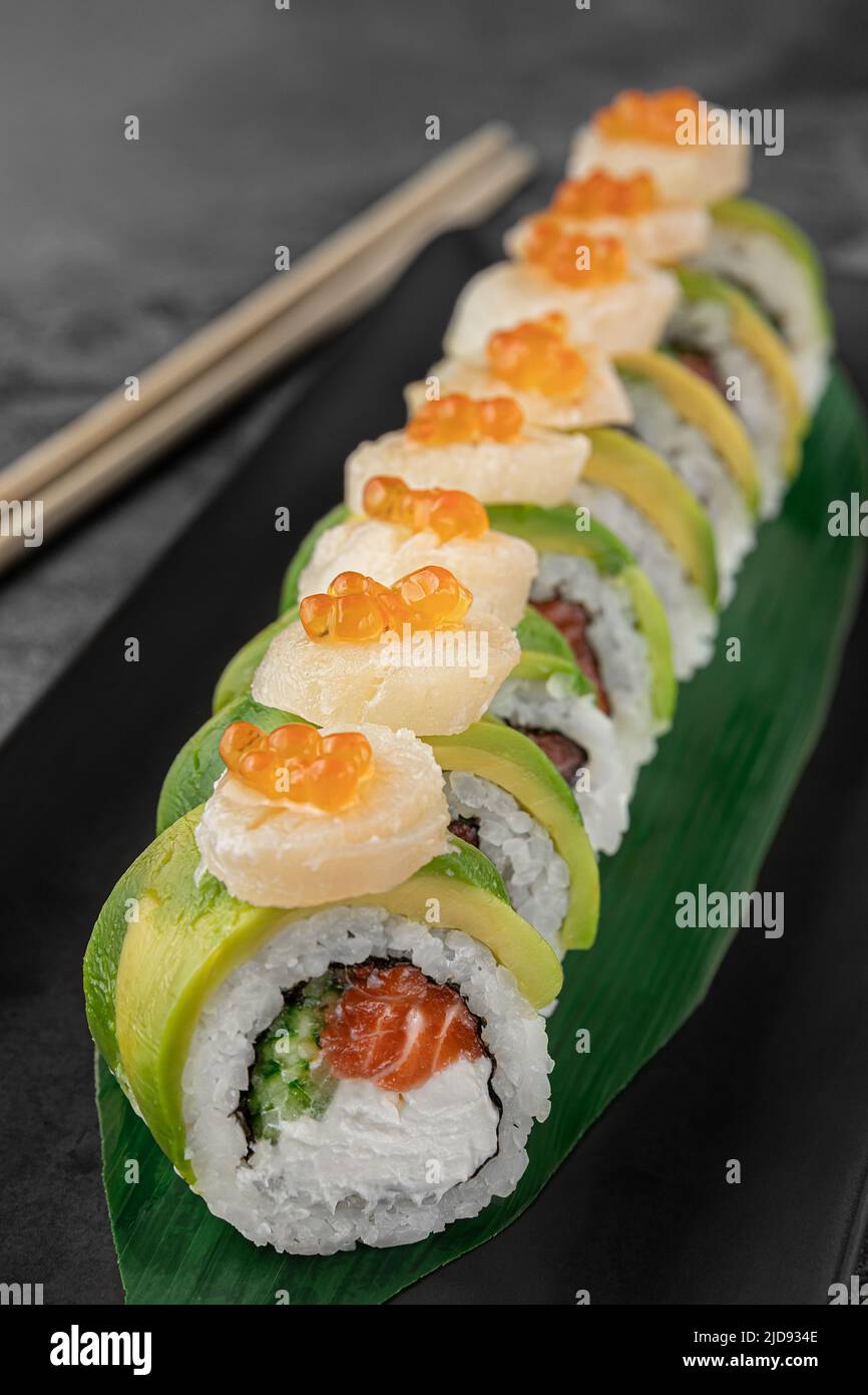 set of maki rolls with cucumber, salmon, caviar and green bamboo leaf ...