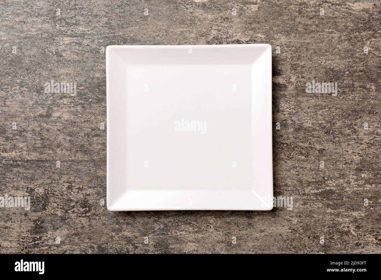 Top view of empty square plate on cement background. Empty space for ...