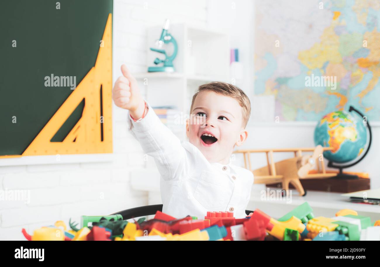 Happy smiling boy with thumb up is going to school for the first time ...