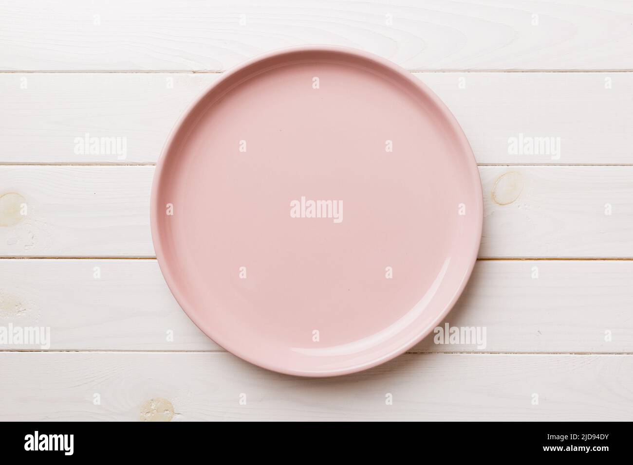 Top view of empty pink plate on wooden background. Empty space for your ...