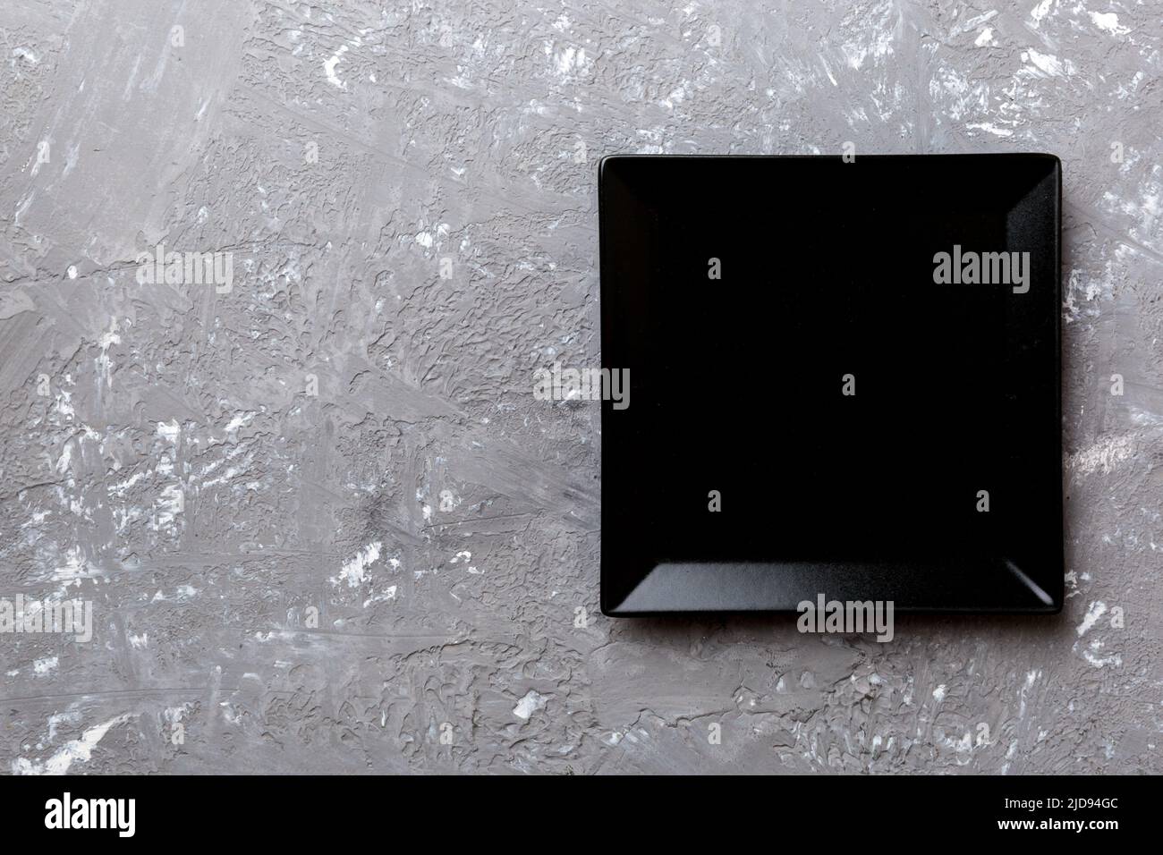 Top view of empty square plate on cement background. Empty space for ...