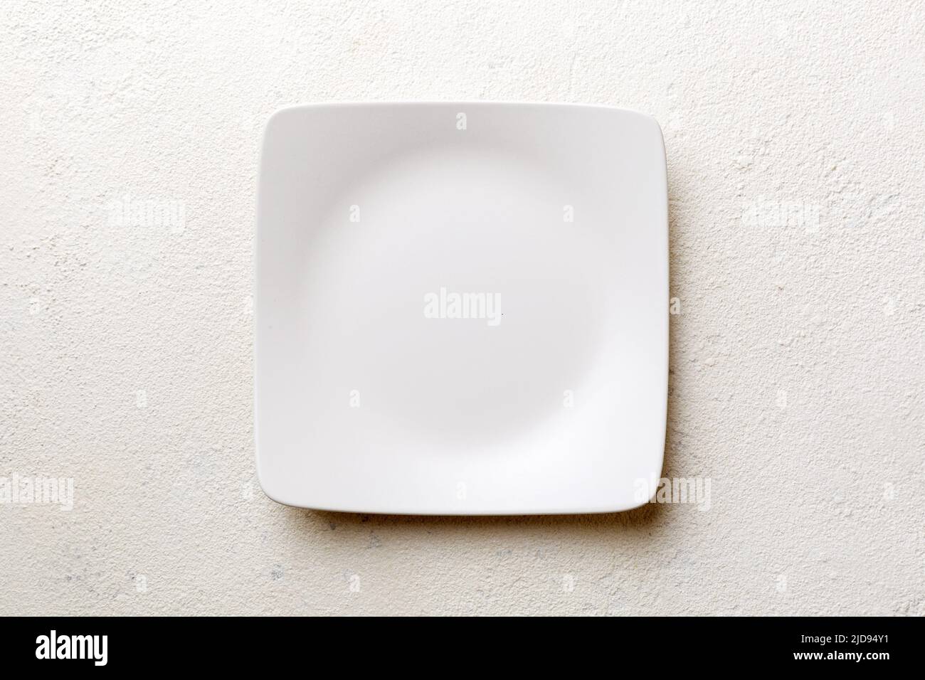 Top view of empty square plate on cement background. Empty space for ...