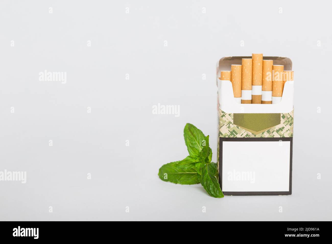 Pack of menthol cigarettes and fresh mint on colored table, Menthol ...