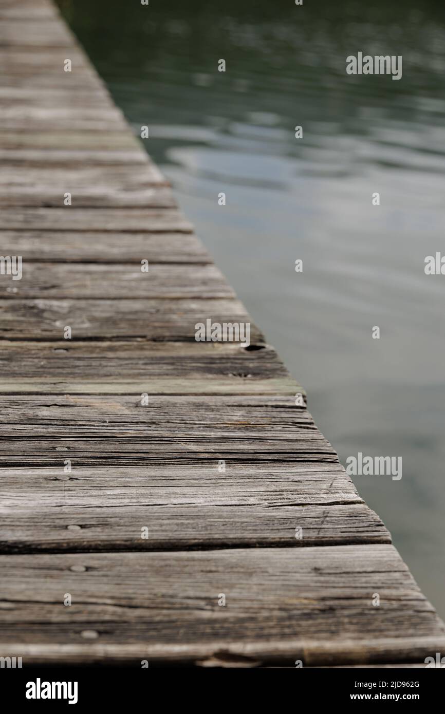 Old wooden planks of a pier reaching over lake water Stock Photo - Alamy