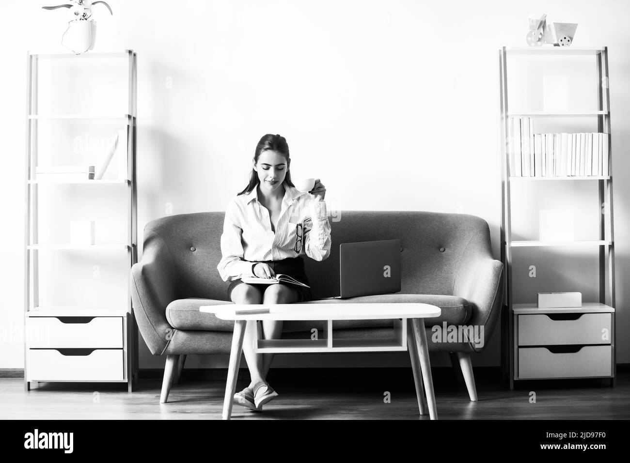 Young attractive secretary woman with cup of coffee in a workplace in ...