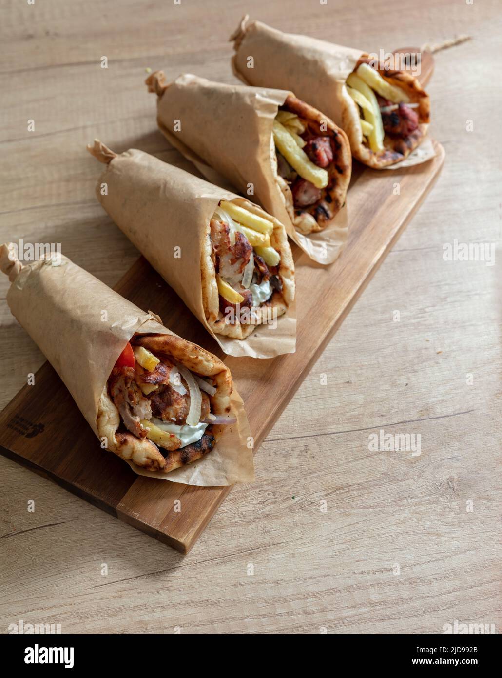 Shawarma Gyro pita on wooden table. Greek food, sliced meat, potato ...