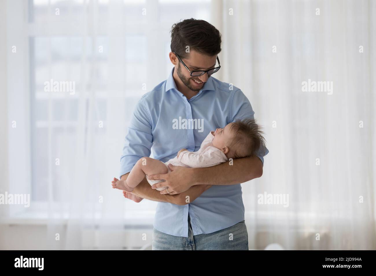 Young caring daddy holding on arms his baby Stock Photo - Alamy