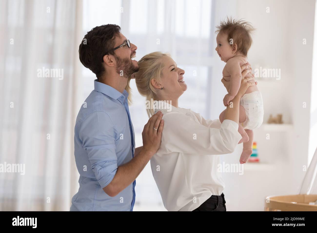 Parents enjoy playtime with their adorable baby Stock Photo - Alamy