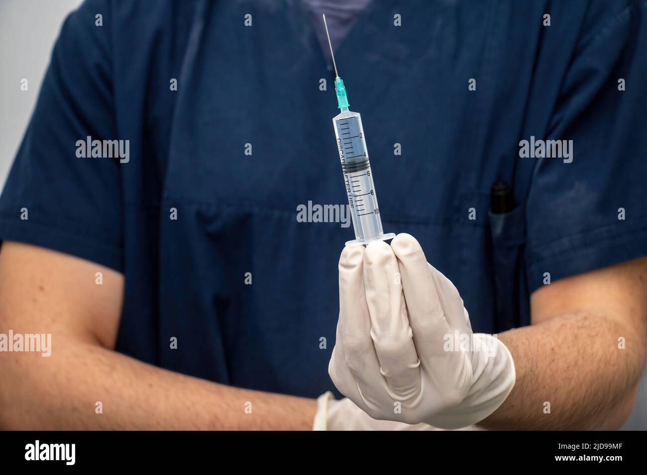 Doctor in medical uniform holds in hand with disposable glove, liquid ...