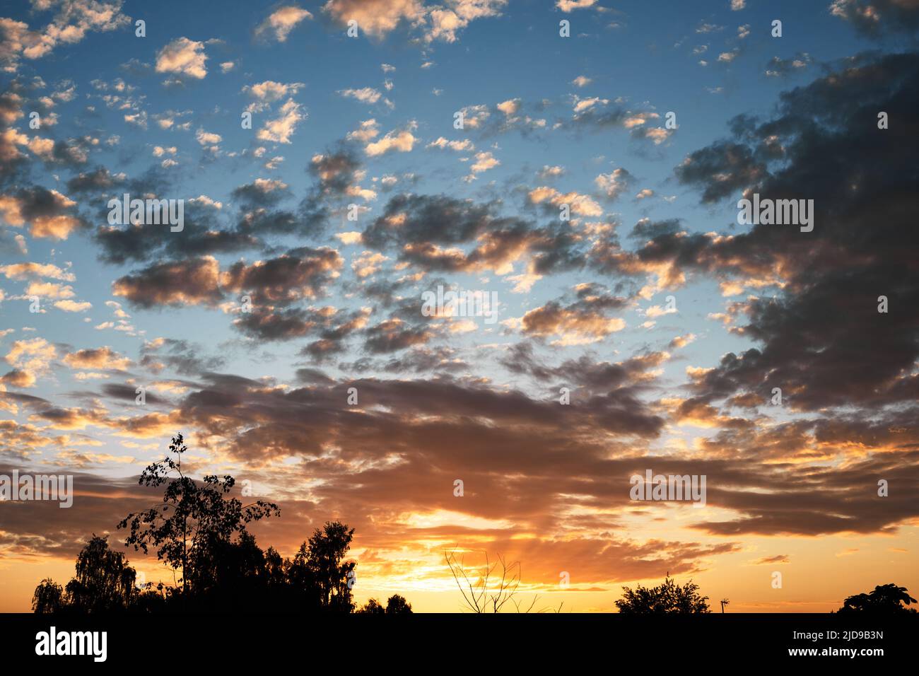 Spring blue sunset sky with bright clouds. Front view Stock Photo - Alamy