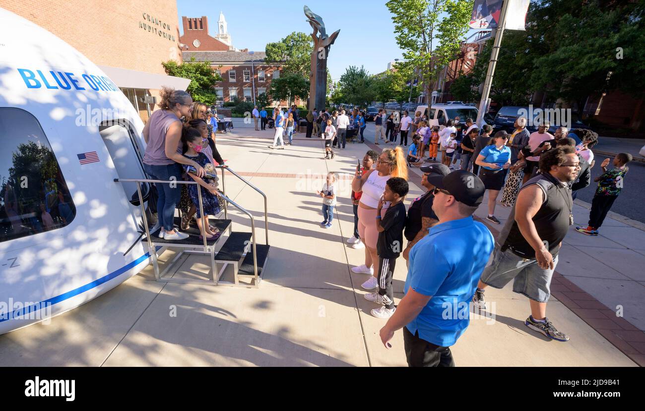 Attendees line up to go inside a Blue Origin New Shepard capsule mockup ...