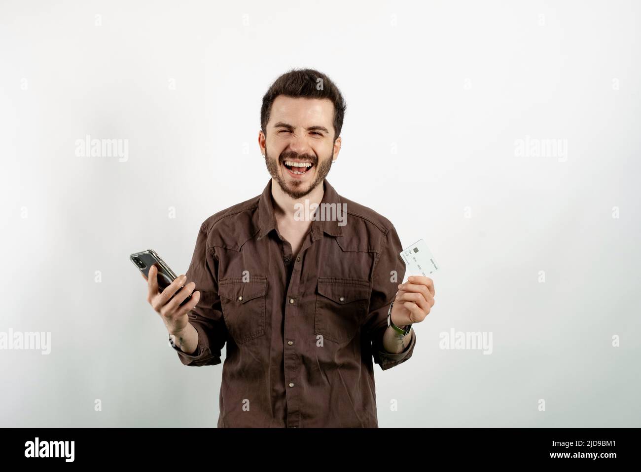 Cheerful caucasian man wearing brown shirt posing isolated over white ...