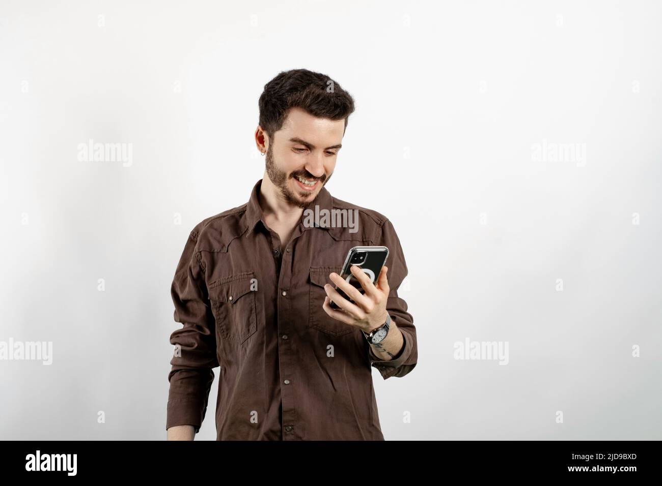Cheerful caucasian man wearing brown shirt posing isolated over white ...