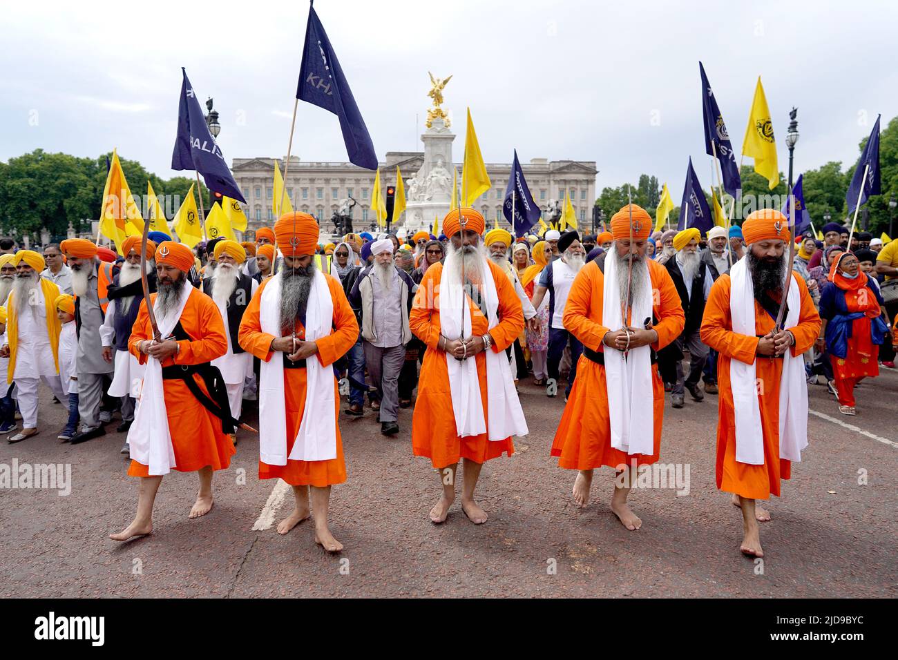 Sikh men hold their swords as they march along The Mall to Trafalgar ...