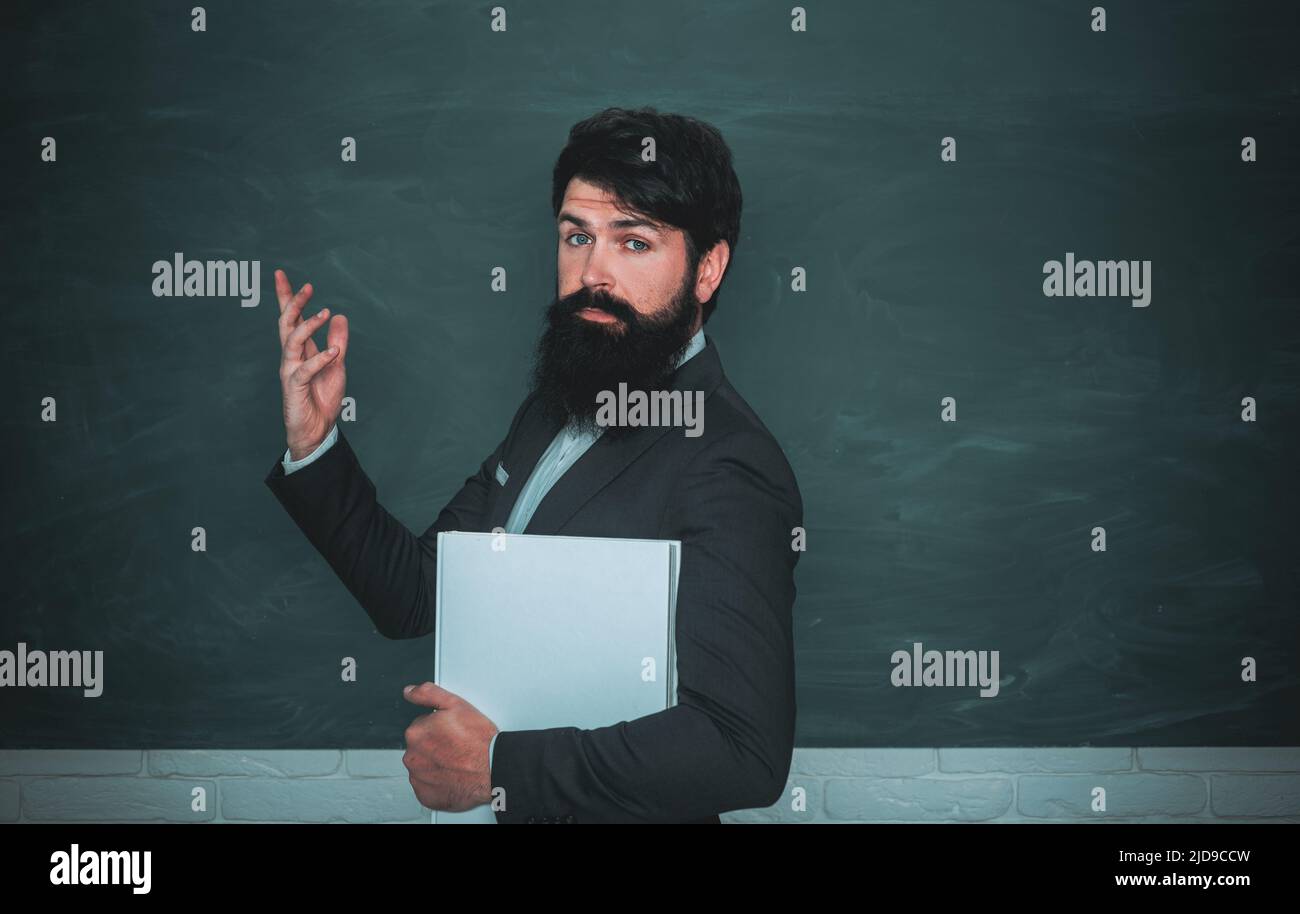 Bearded professor at school lesson at desks in classroom. Back to ...