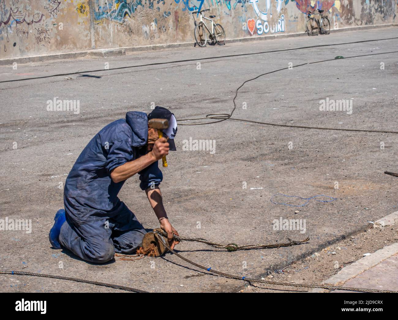 A welder with hammer fixing a ship chain, Essaouira, Morocco Stock ...