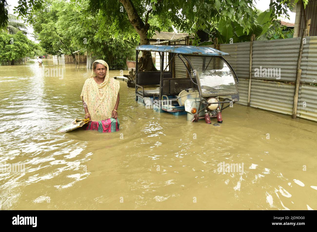 Guwahati, Guwahati, India. 19th June, 2022. A woman wades through the flood water at Rangia in ...