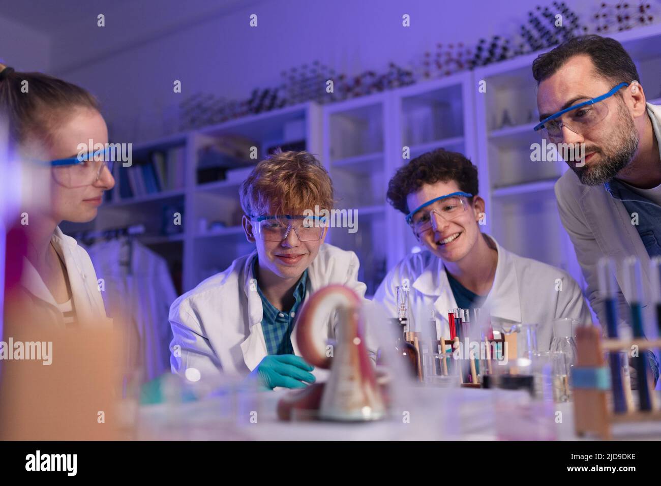 Science students with teacher doing chemical reaction experiment in the ...