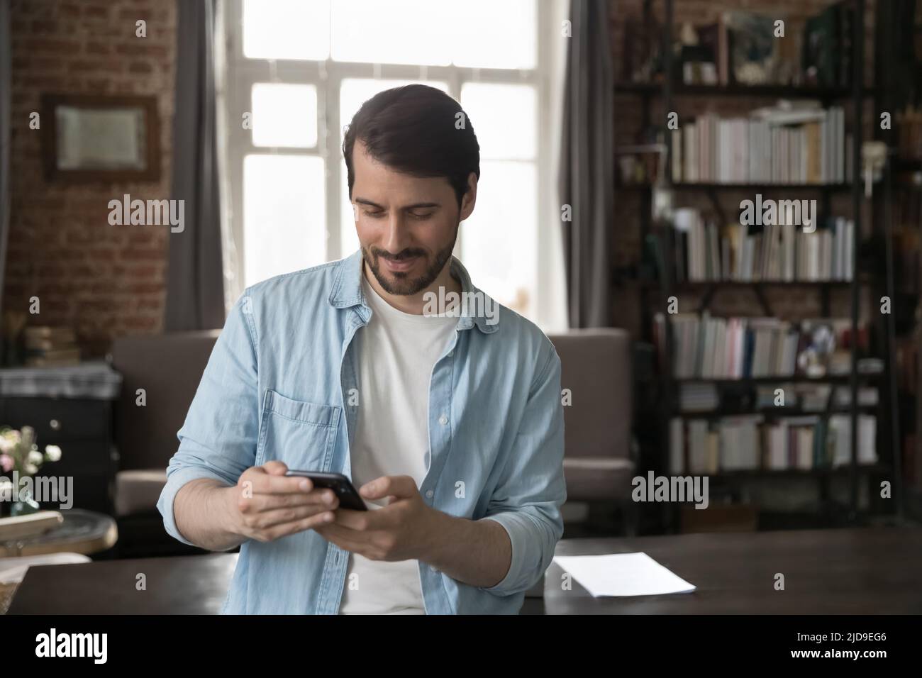 Man use smartphone standing in home office with modern smartphone Stock ...