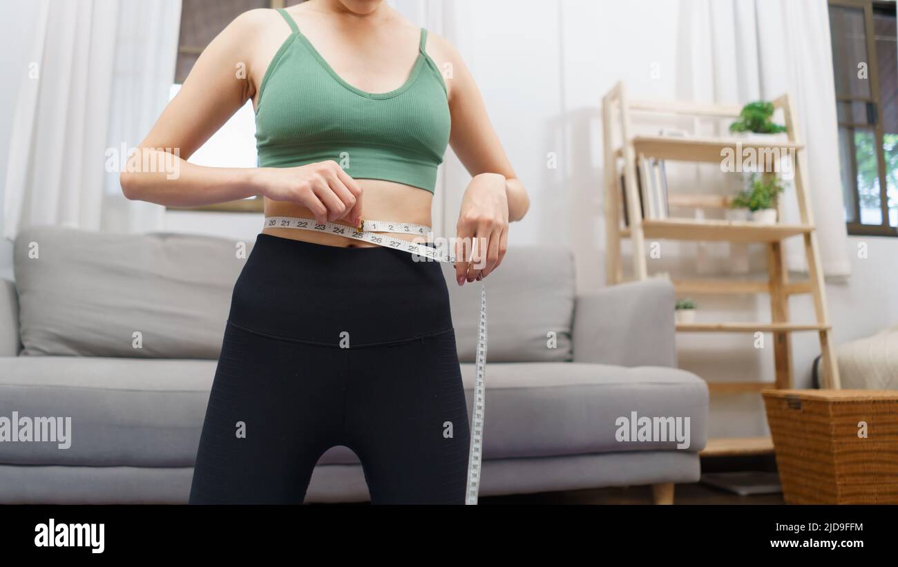 Healthy and weight loss concept, Young Asian woman is measuring her ...