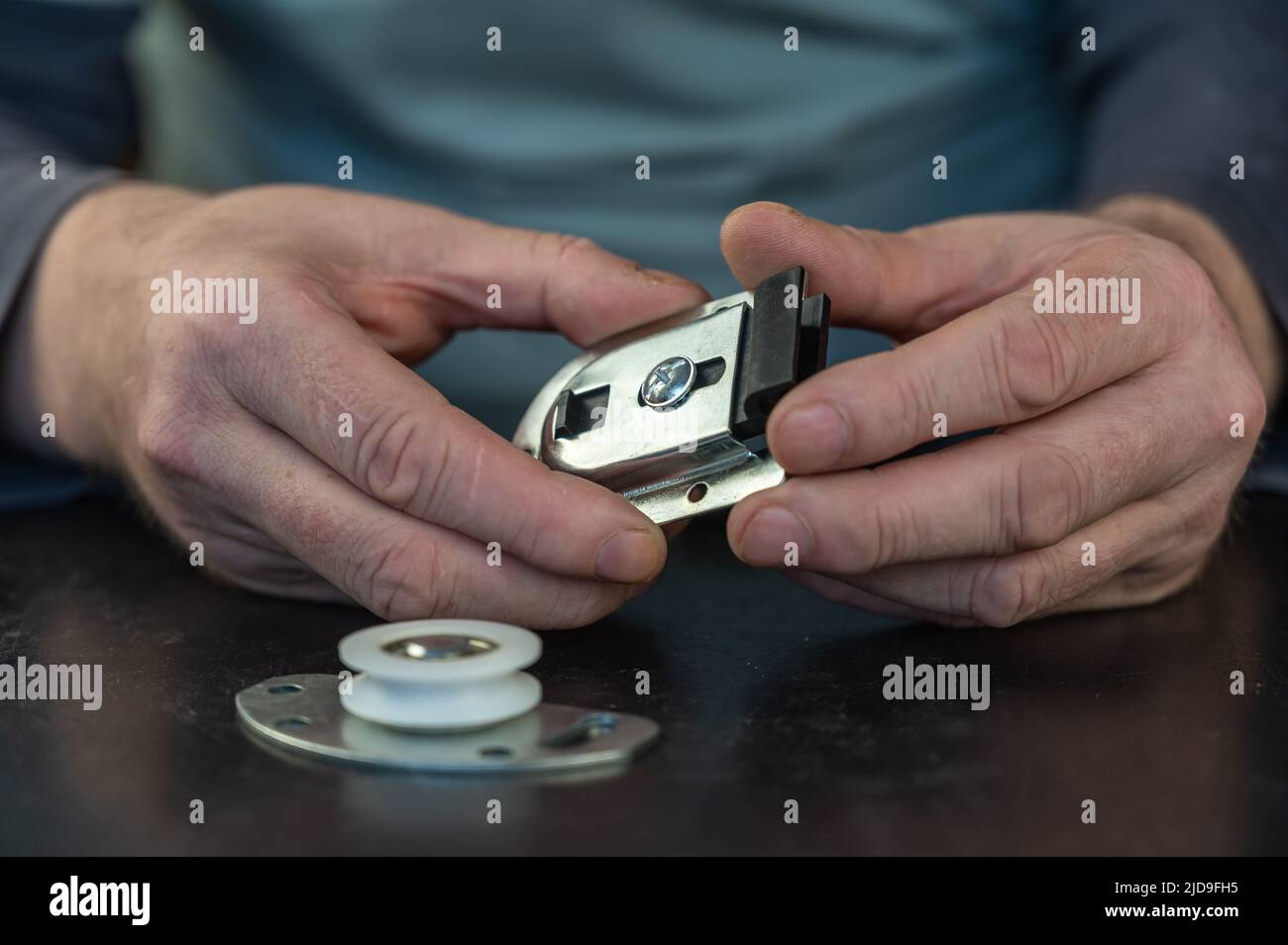 A grown man is holding a set of furniture fittings in his hands. Top ...