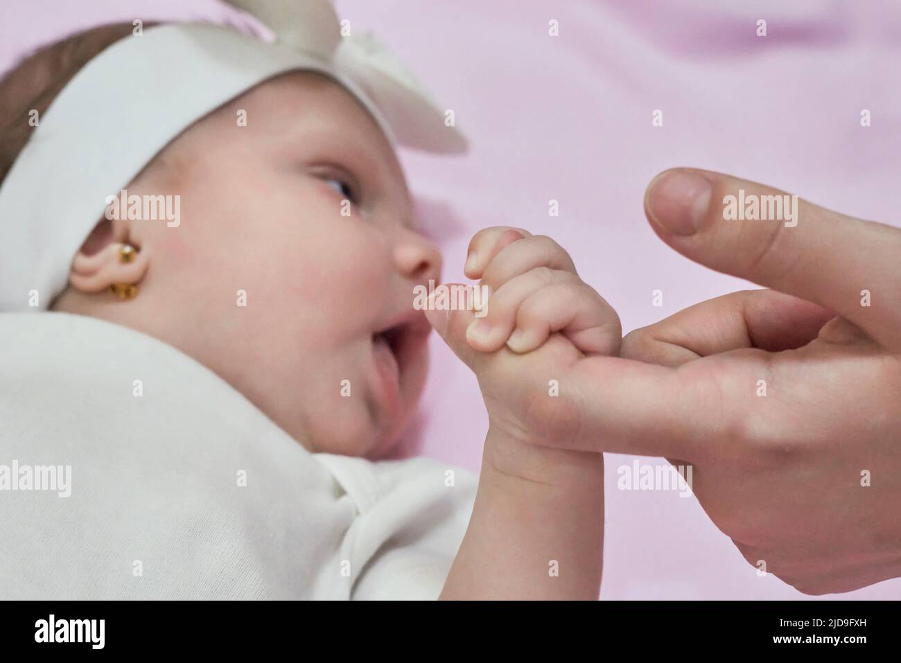 Close-up of sleeping baby hand in the mother's hand on the bed. New ...