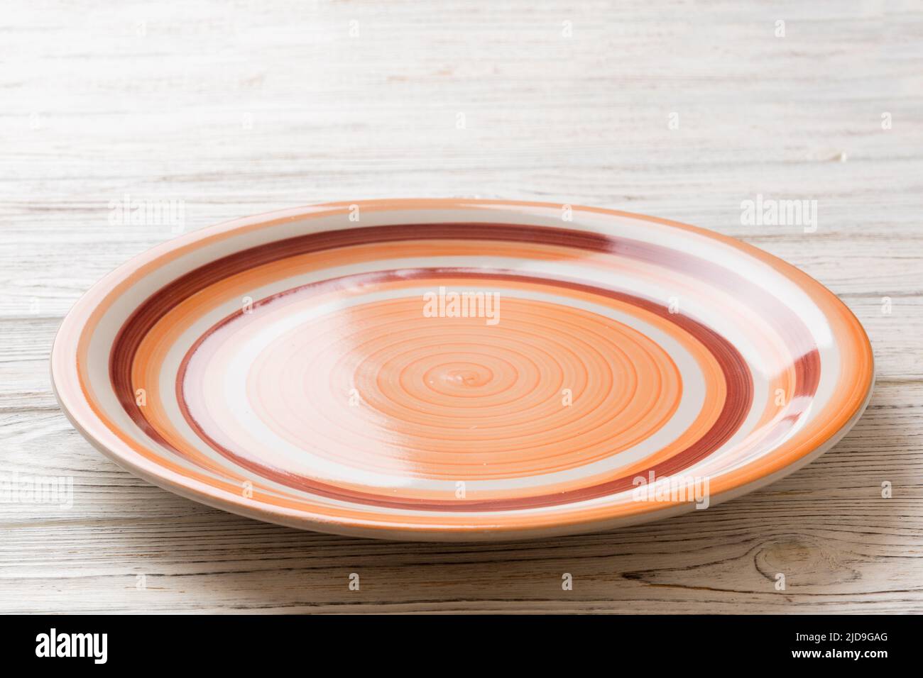 Perspective view of empty orange plate on cement background. Empty ...