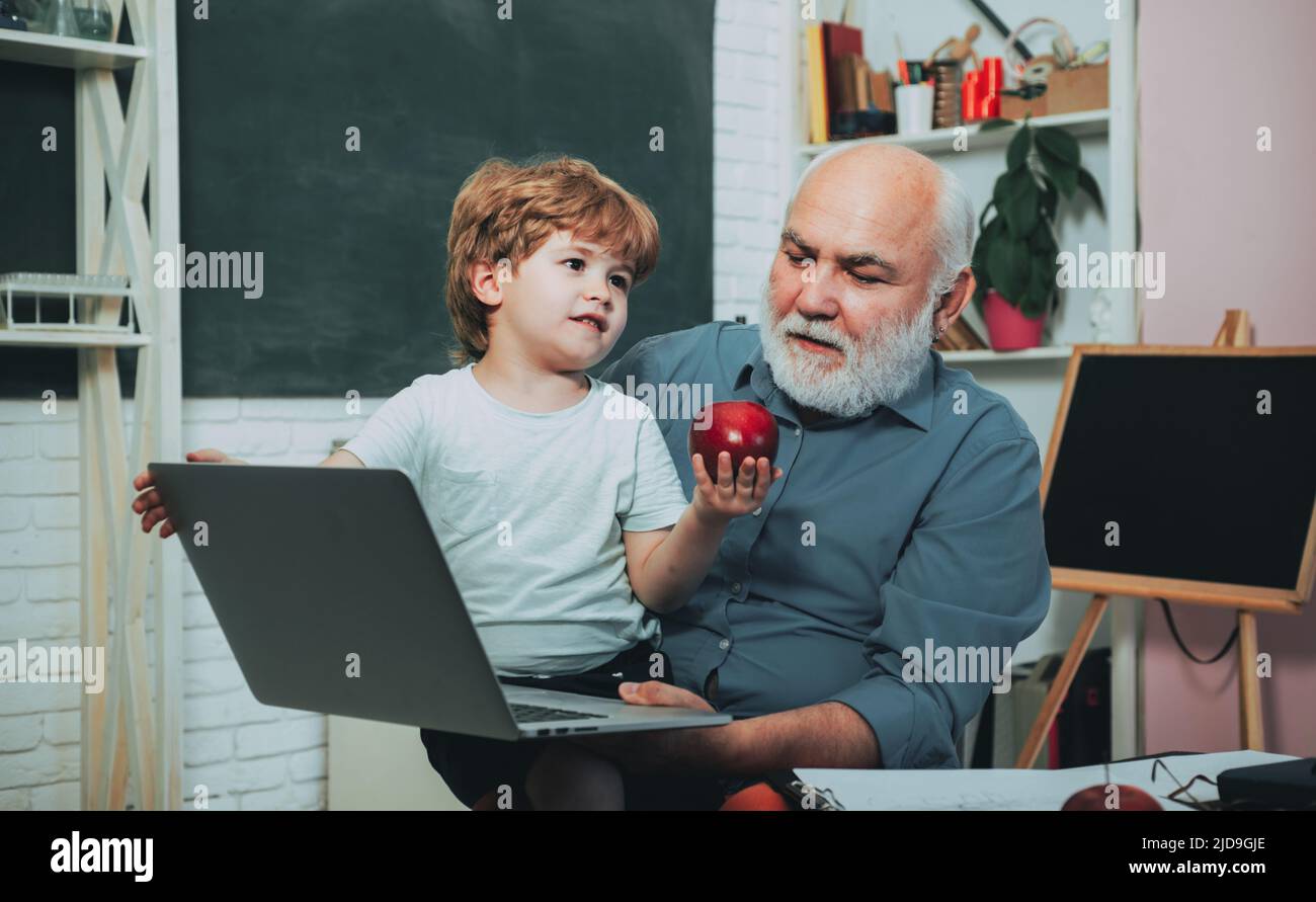 Teacher and pupil learning together in school. Old and Young. Kid with ...