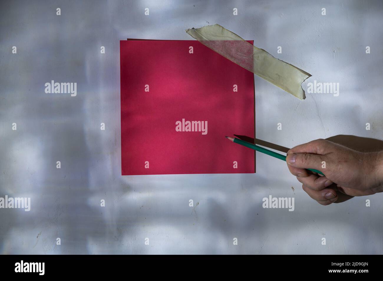 Mature man's hand points to a piece of paper with a pencil. Empty red ...