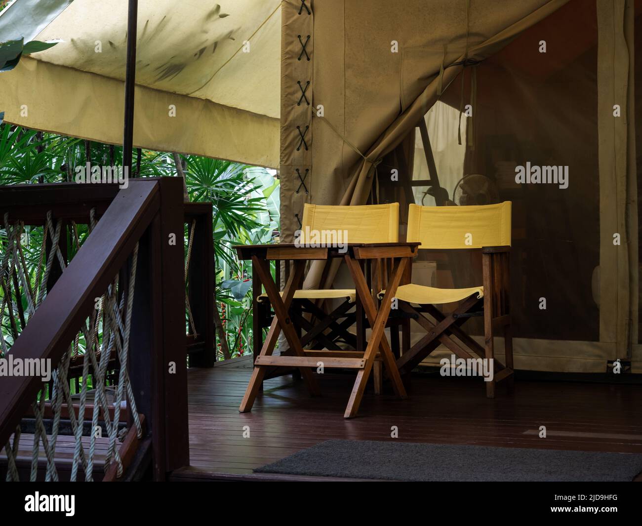 Two empty camping wooden chairs with yellow fabric seats and backrest ...