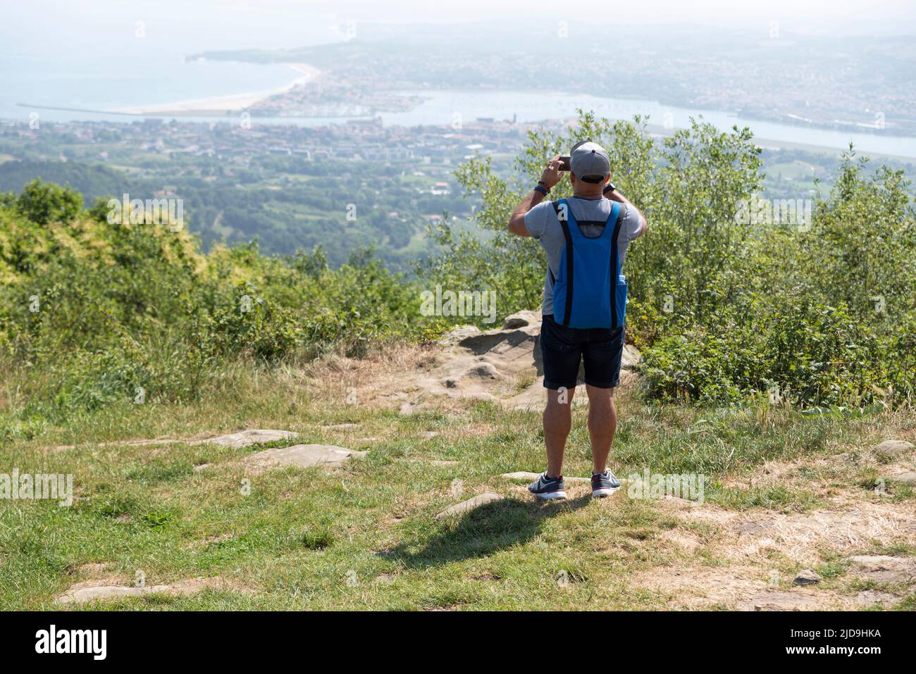 hiker man watching from the top of the mountain Stock Photo - Alamy