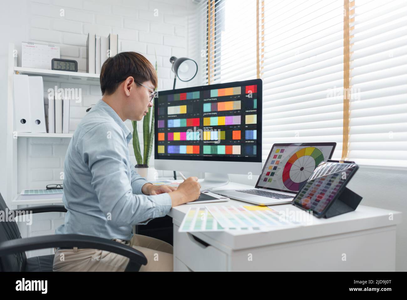 Creativity concept, Male graphic designer using tablet and looking ...