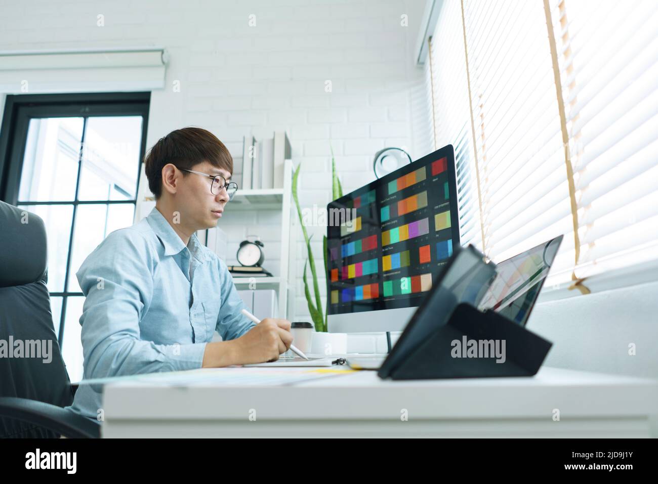 Creativity concept, Male graphic designer using tablet and looking ...