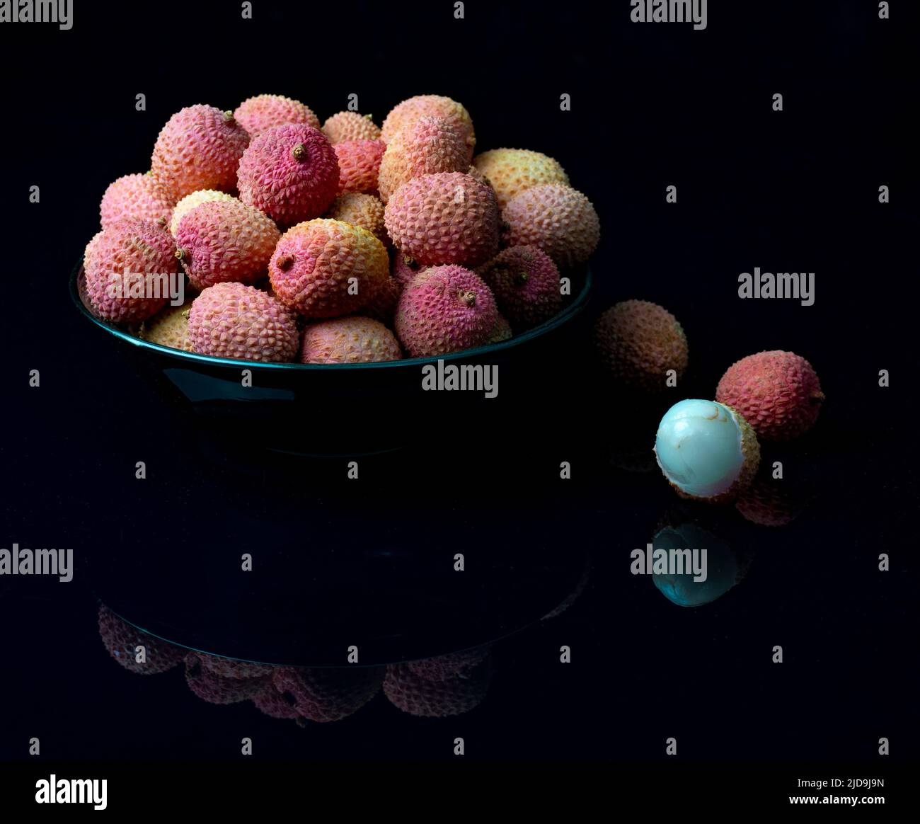 Bowl of lyche fruit on reflective surface Stock Photo - Alamy