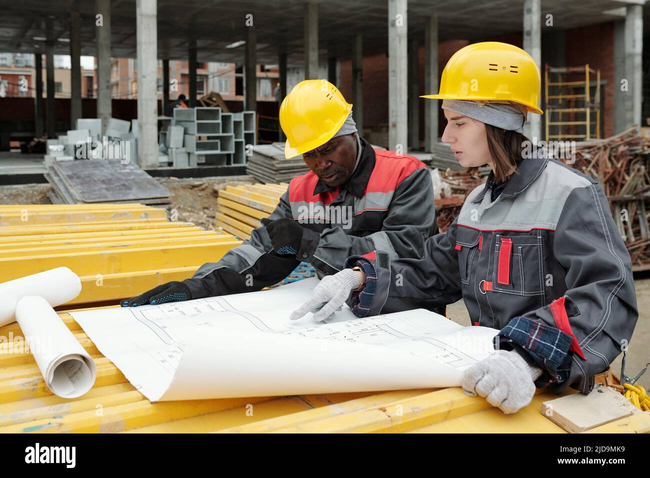 Young confident female engineer pointing at sketch of building on ...