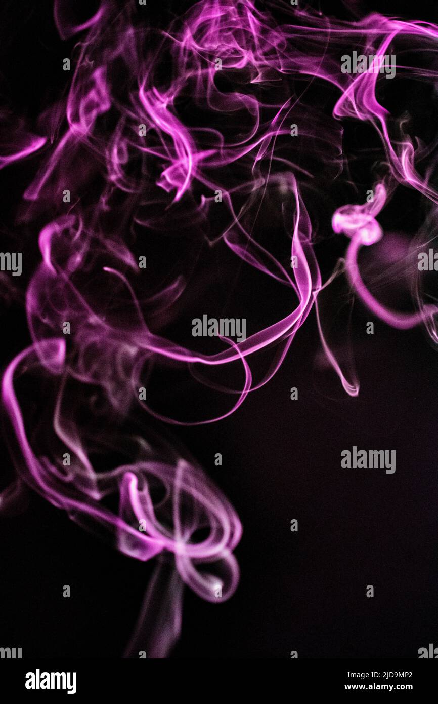 A swirling, ascending smoke pattern with a purple pinkish hue on a ...