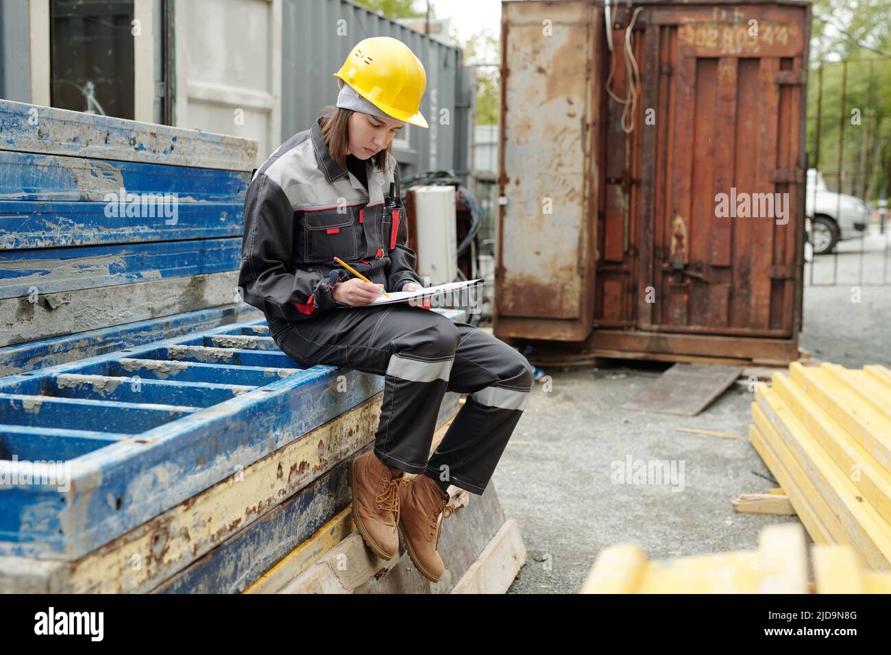 Modern female engineer in workwear drawing sketch of construction on ...