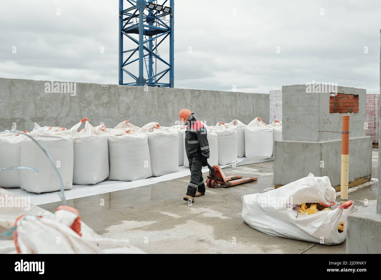 African American male worker of construction site pulling empty cart ...