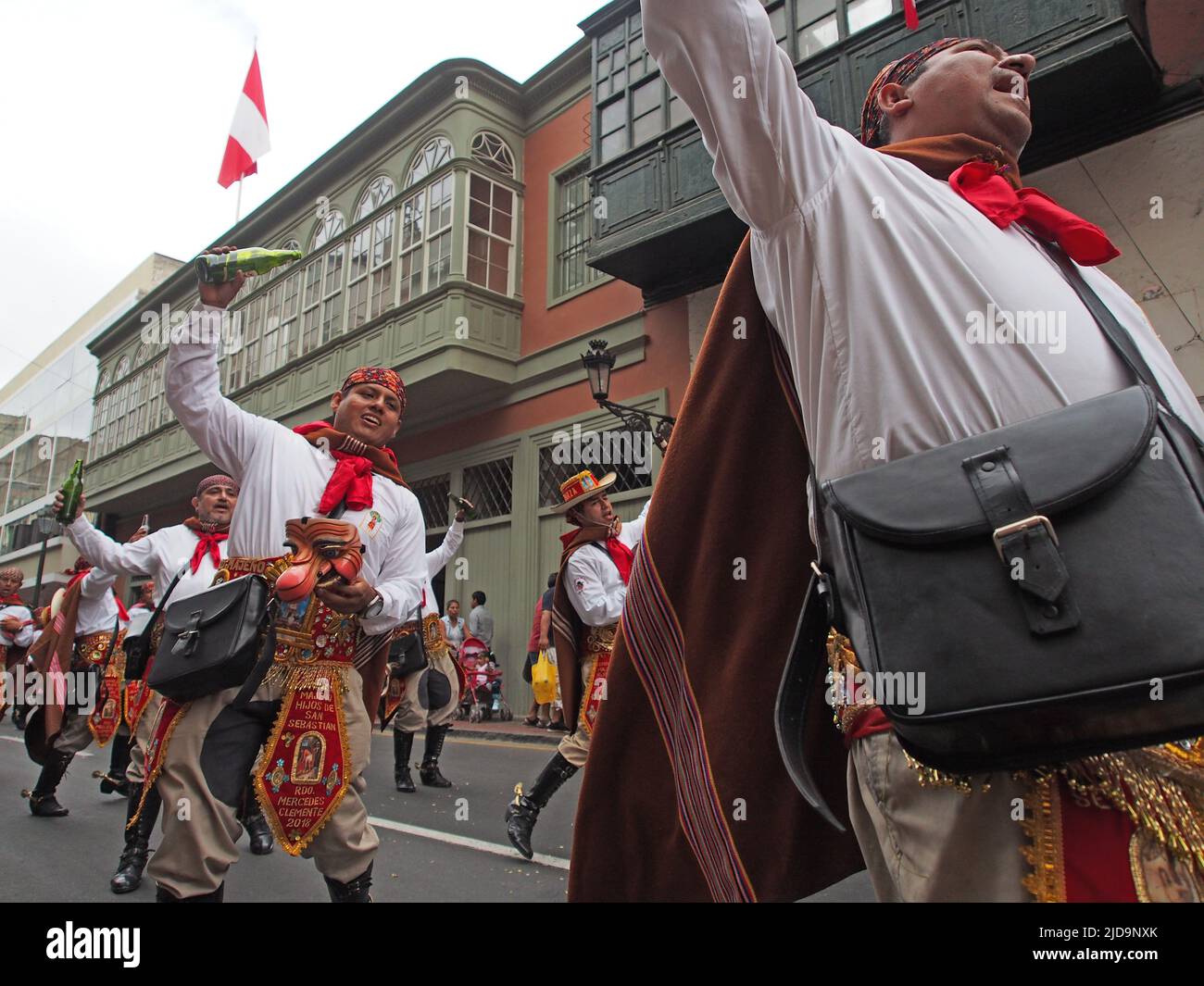 Indigenous men wearing andean typical costume, dancing with a beer ...