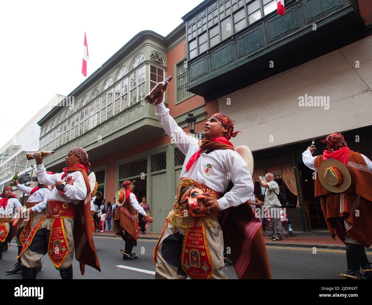 Indigenous men wearing andean typical costume, dancing with a beer ...