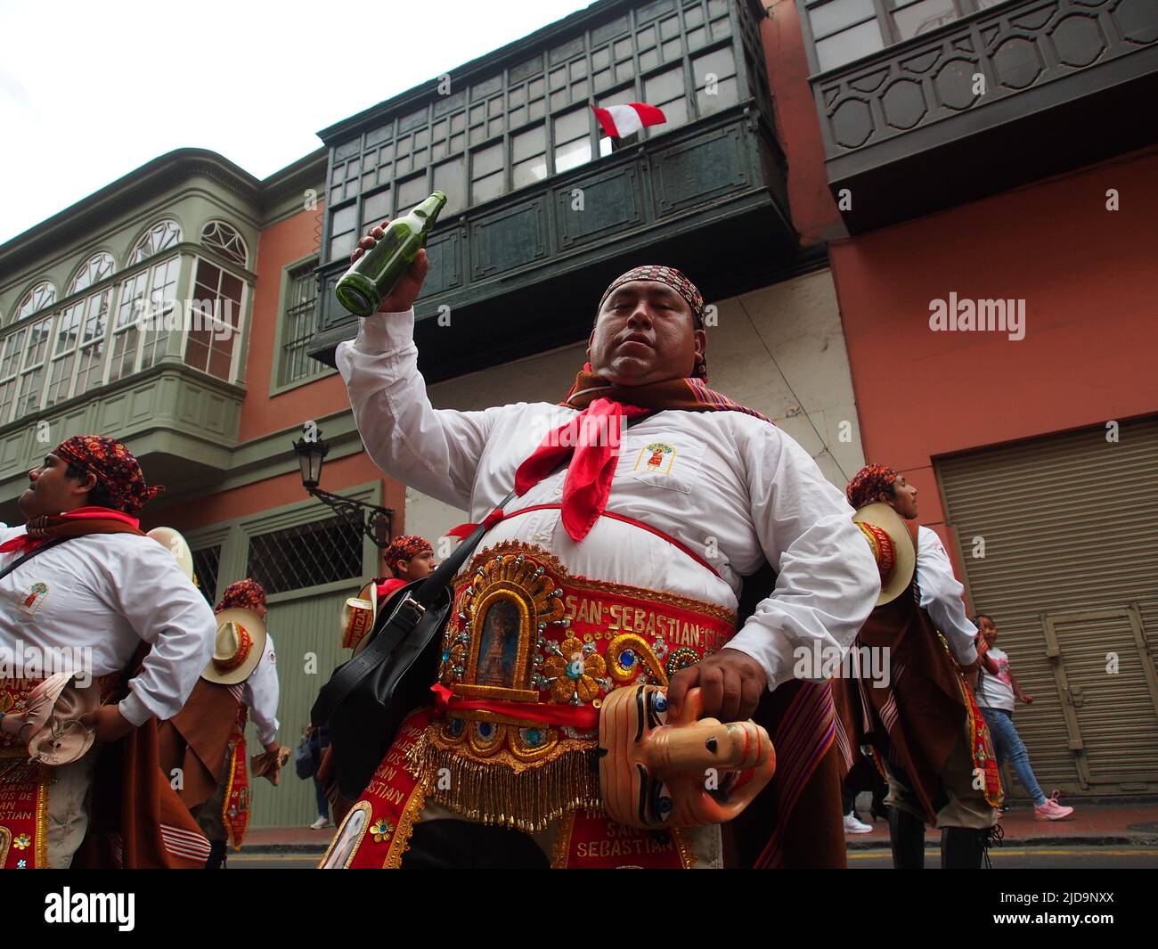Indigenous men wearing andean typical costume, dancing with a beer ...